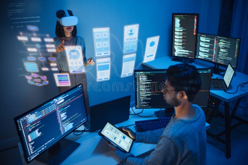 Developer Uses a VR Headset To Interact with Projected Interface Designs, while Colleagues ...