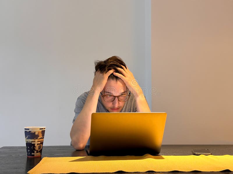 The Developers Face Expresses Desperation, Hands Wrapped Around His ... The Developers Face Expresses Desperation, Hands Wrapped Around His ...