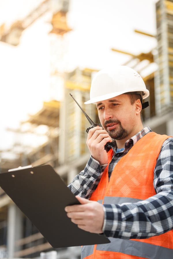 Developing Engineer Wearing White Safety Vest and Hardhat with W Stock ...