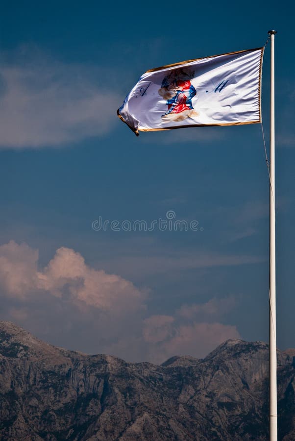 Developing the Flag on the Flagpole on the Background of Mountains and ...