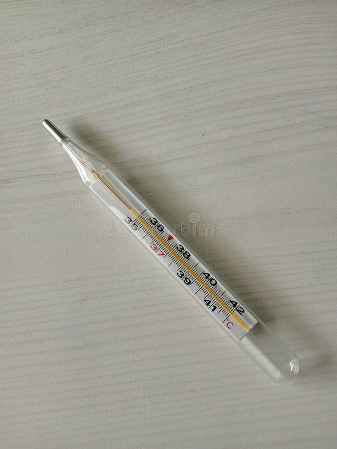 A Device for Checking Body Temperature, a Thermometer. on a White Table ...