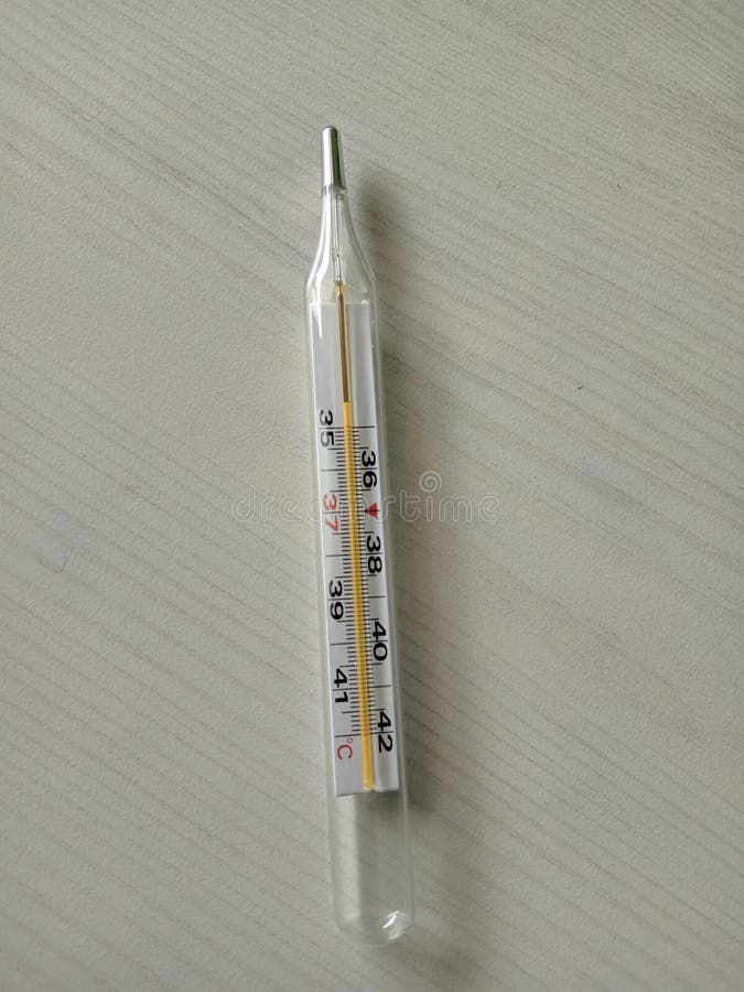 A Device for Checking Body Temperature, a Thermometer. on a White Table ...