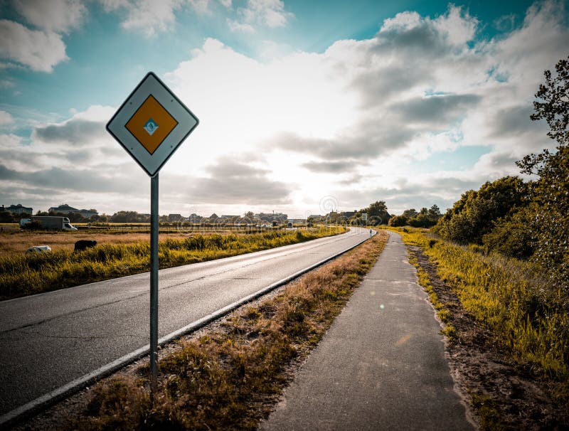 Diamond Shape Road Sign in the Middle of the Path Surrounded by Plants ...