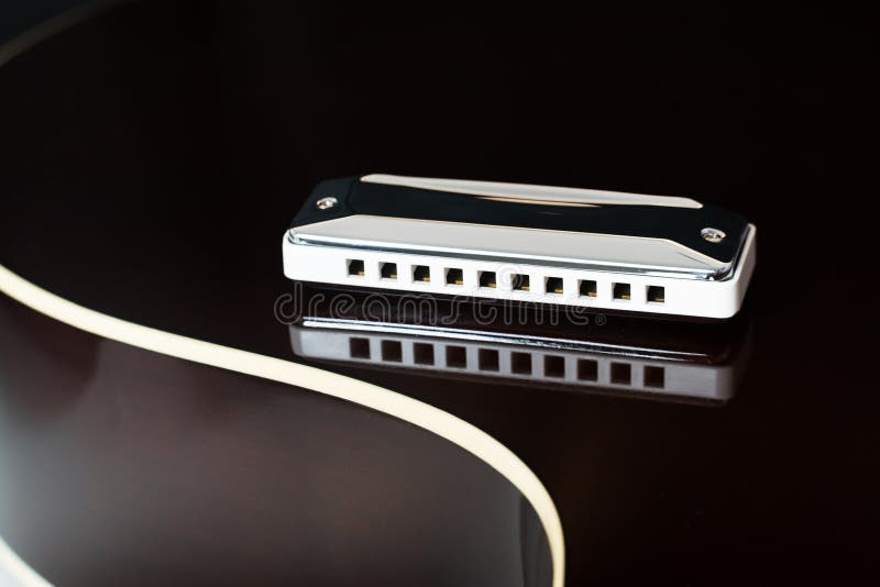 Diatonic Harmonica Lying on the Back of Acoustic Guitar Stock Photo ...