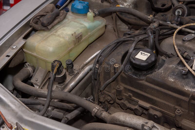 Diesel Engine in the Car and Plastic Water Reservoir. Dirty Old Diesel ...