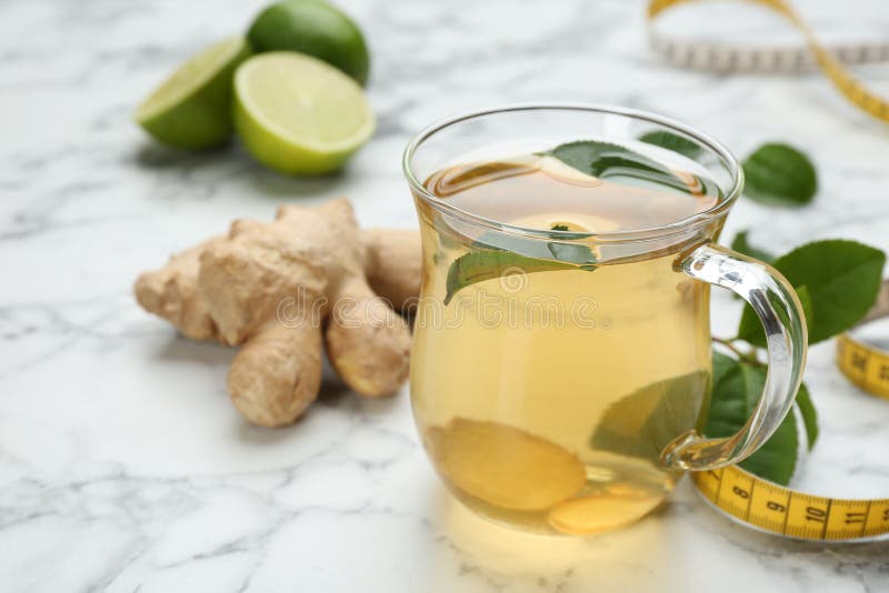 Diet Herbal Tea with Green Leaves and Ginger on White Marble Table ...