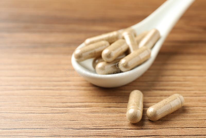 Dietary Supplement Capsules with Spoon on Wooden Table, Closeup. Space ...