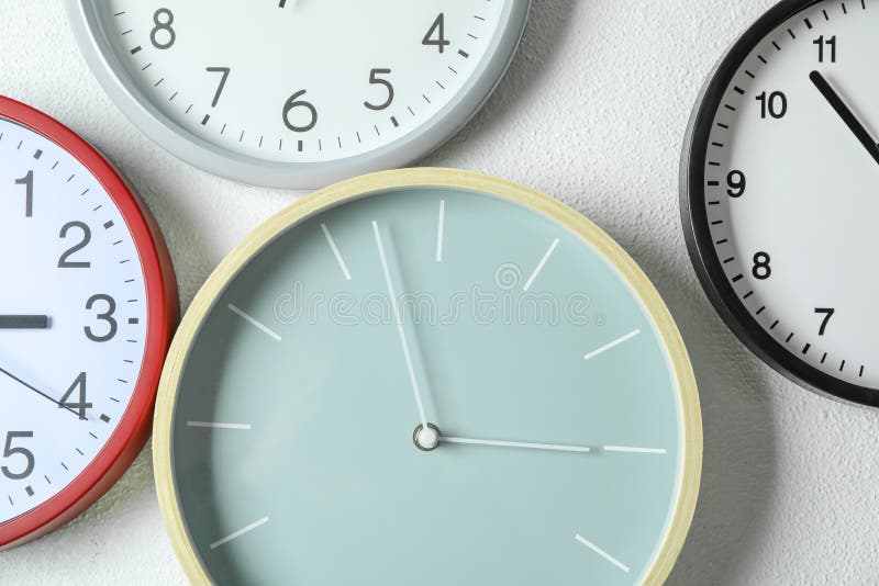 Different Beautiful Clocks Hanging on Light Wall Stock Image - Image of ...