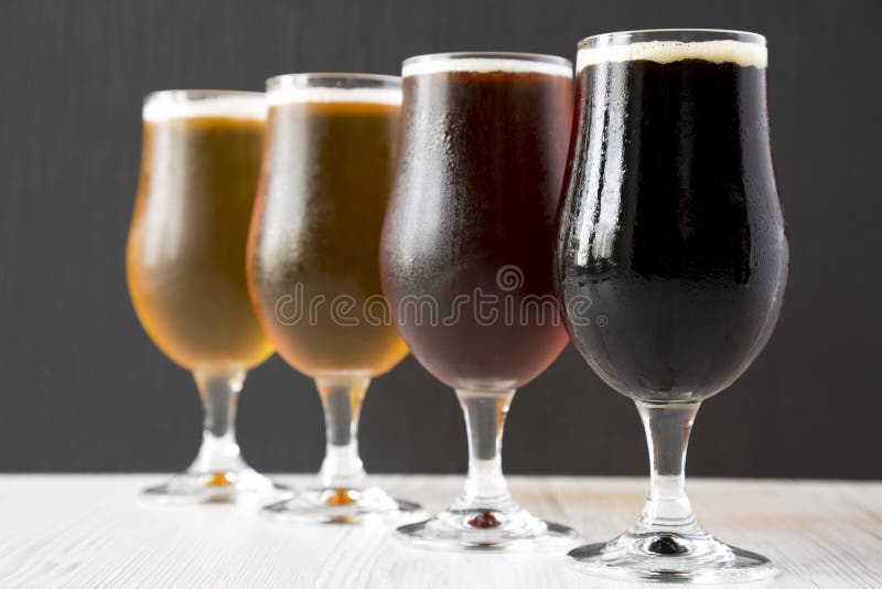 Different Beers in Glasses with Foamy Tops and Condensation. Stock ...