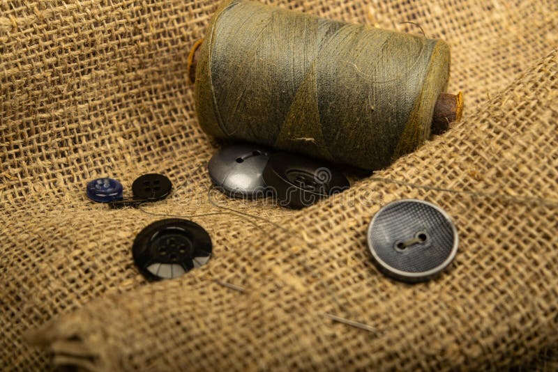 Different Buttons and a Spool of Thread on the Burlap with a Rough ...