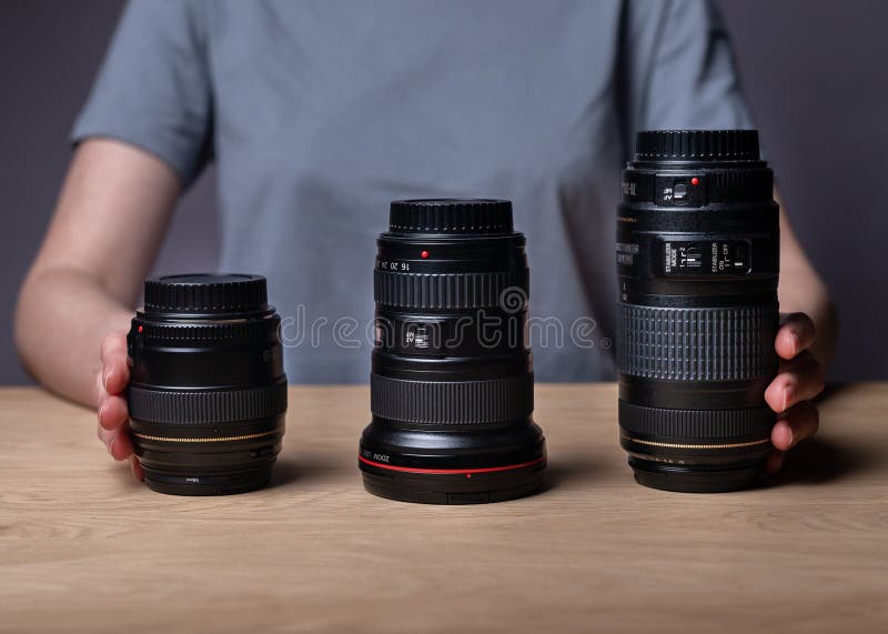Different Camera Lenses on Wooden Table. 85 Mm, 35 Mm and 300 Mm Stock ...