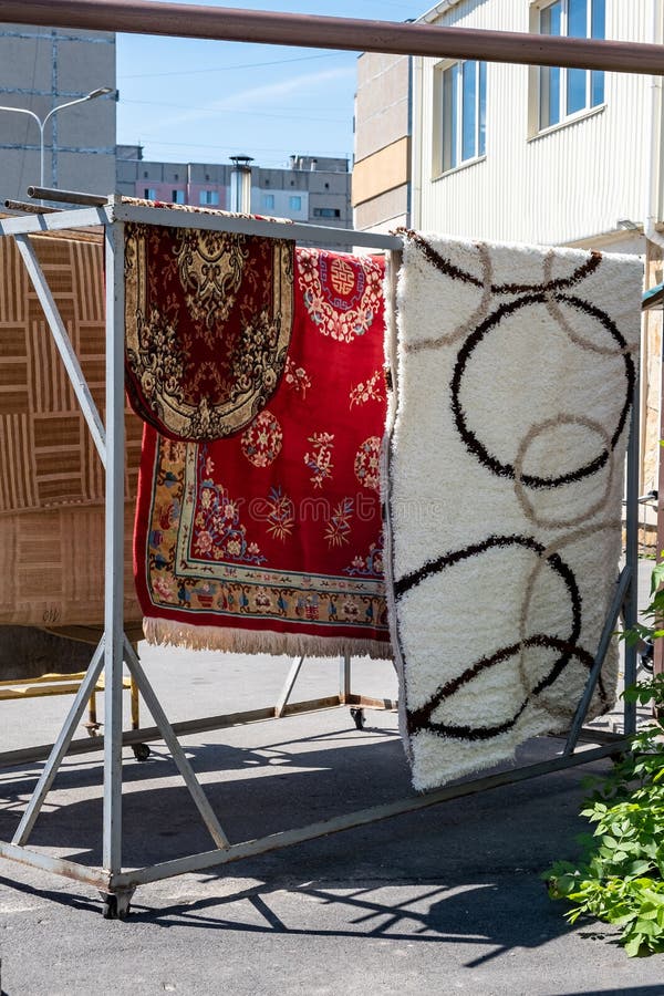 Different Carpets Hanging on Rack Outdoors. Professional Carpet ...