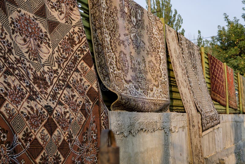 Different Carpets Hanging on Rack Outdoors. Professional Carpet ...