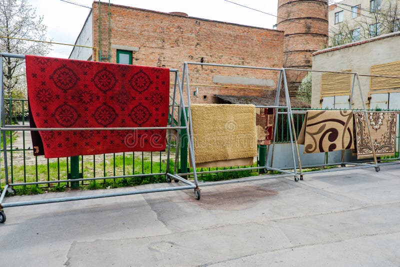 Different Carpets Hanging on Rack Outdoors. Professional Carpet ...