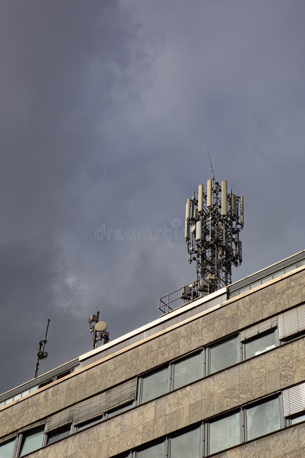 Different Cell Phone Masts on a Building in Front of a Cloudy Sky Base ...
