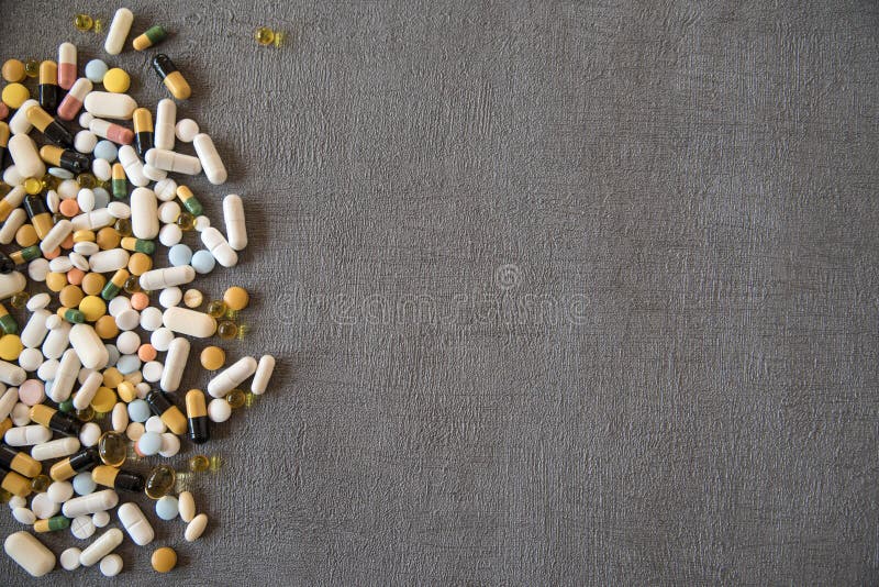 Different Colored Medications and Tablets on Grey Texture Background ...
