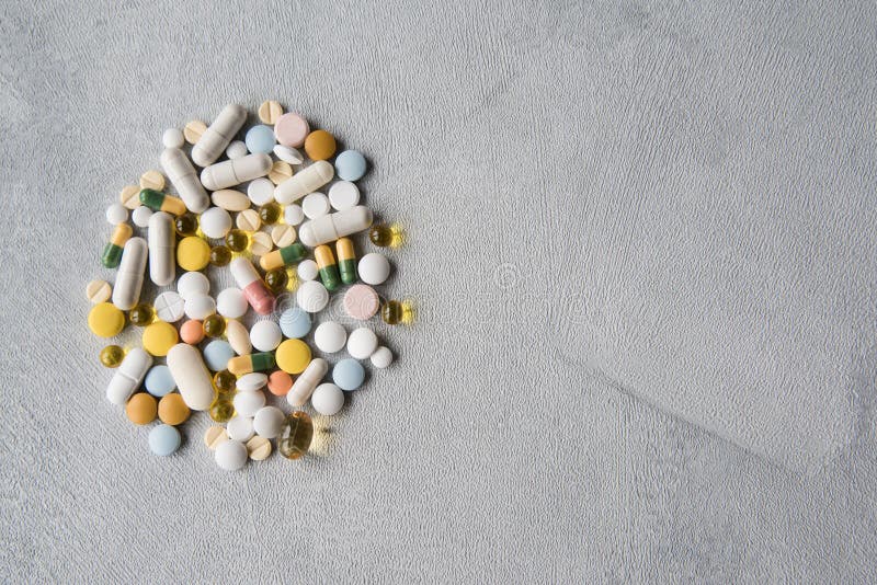 Different Colored Medications and Tablets on Grey Texture Background ...