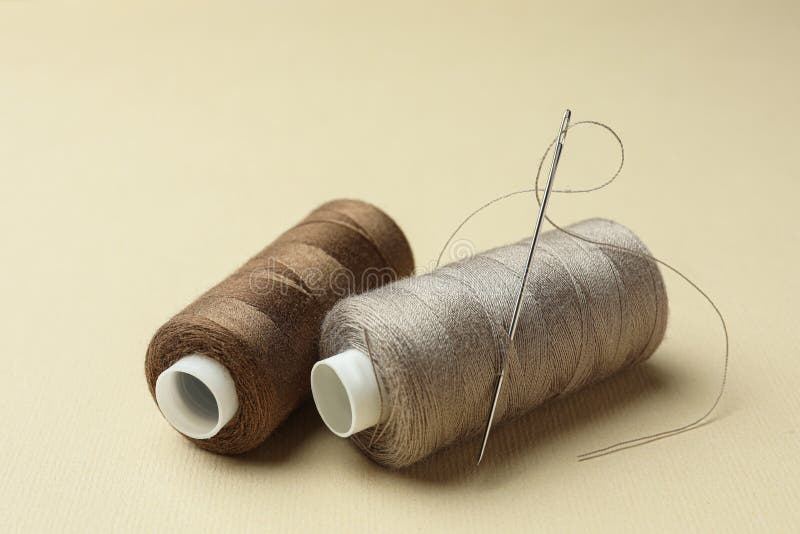 Different Colorful Sewing Threads with Needle on Beige Background Stock ...