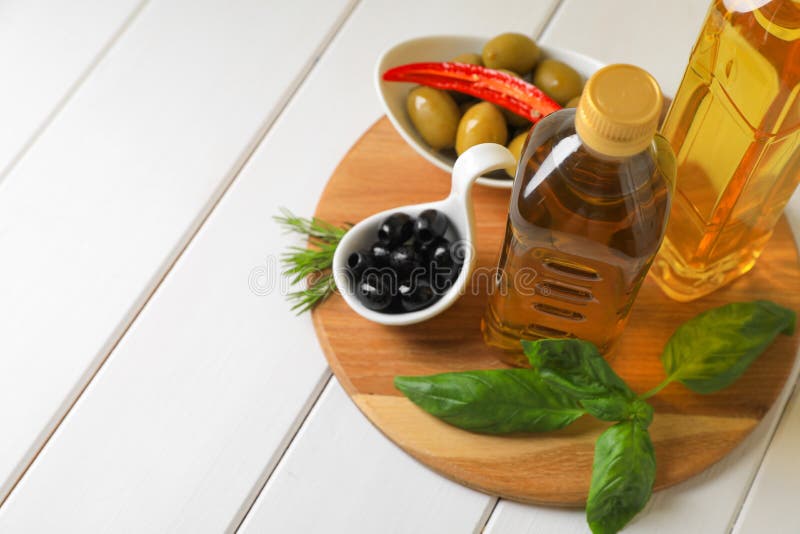 Different Cooking Oils and Ingredients on White Wooden Table, Space for ...