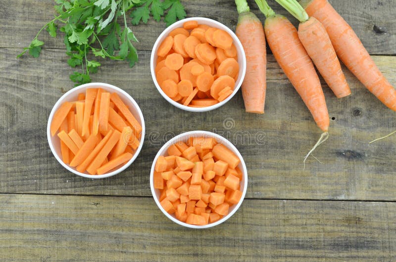 Different Cuts of Carrot in Bowls on Wooden Background, Top View Stock ...