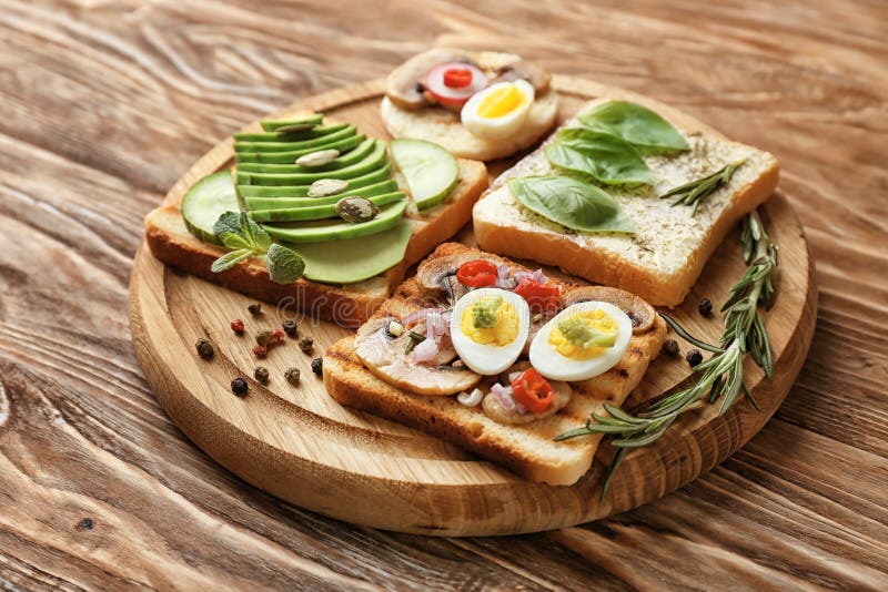 Different Delicious Toasts on Wooden Board Stock Photo - Image of ...