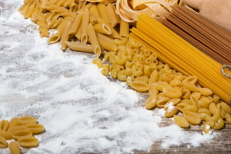 Different Dry Pasta on a Wooden Board with Flour Stock Photo - Image of ...