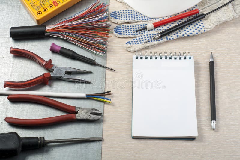.Set of Electrical Tools, White Helmet and Notepad on Metallic ...
