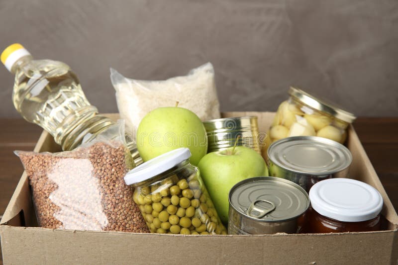 Different Food Products for Donation in Box on Table, Closeup Stock ...