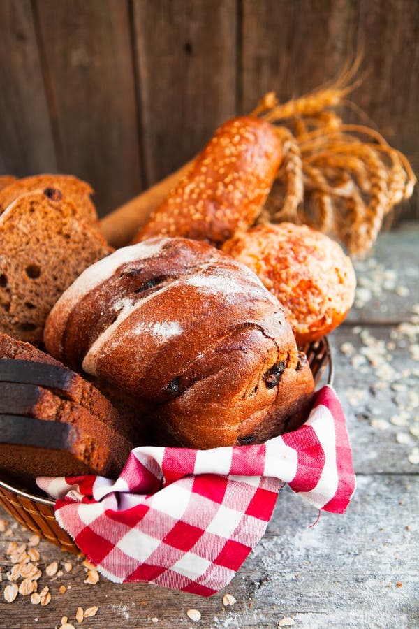 Different Fresh Bread in Wicker Basket on Rustic Table on Wooden Stock ...