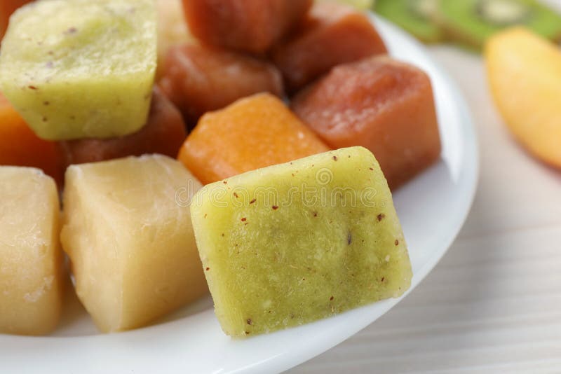 Different Frozen Fruit Puree Cubes on White Wooden Table, Closeup Stock ...