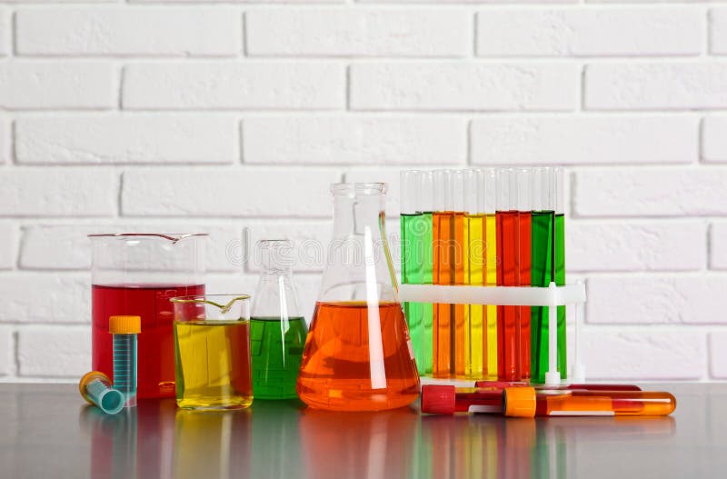 Different Glassware with Samples on Table Near Brick Wall Stock Photo ...