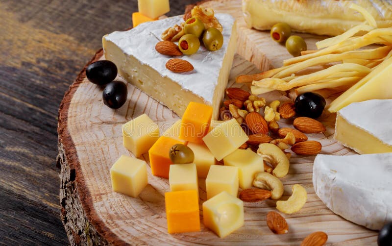 Different Kinds Of Cheese, Olives And Assorted Nuts Wood Background ...