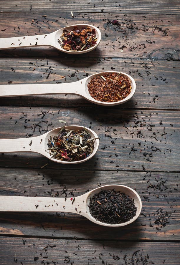 Different Kinds of Tea in Jar and Wooden Spoons on Wood Table Stock ...