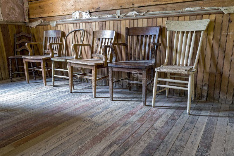 Different Kinds of Wood Chairs Lined Up Against a Wall in an Abandoned ...
