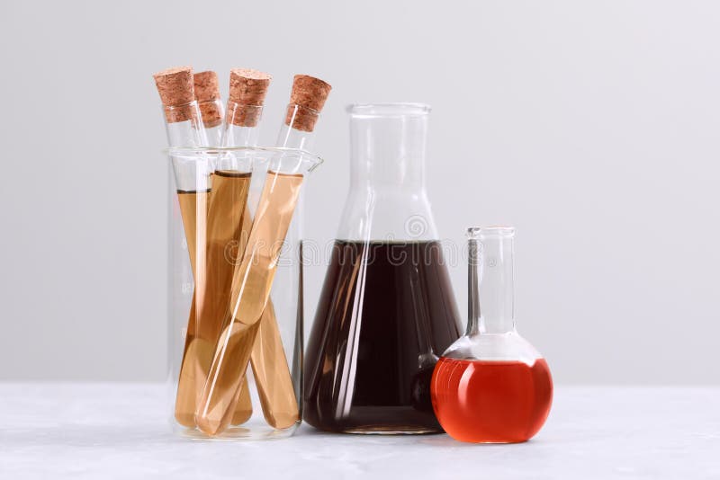Different Laboratory Glassware with Brown Liquids on White Table ...
