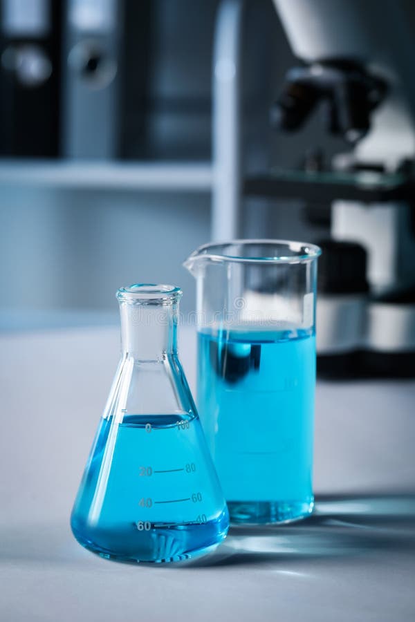 Different Laboratory Glassware with Light Blue Liquid on Table Stock ...