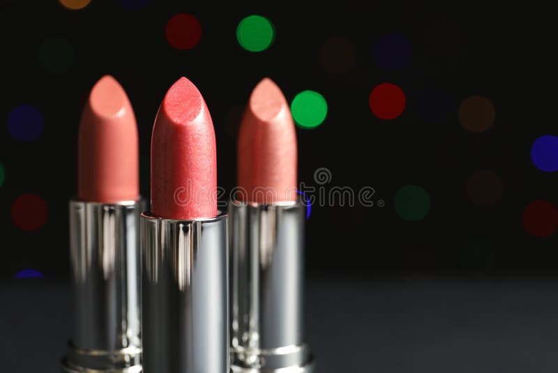Different Lipsticks on Table Against Blurred Lights. Stock Photo ...