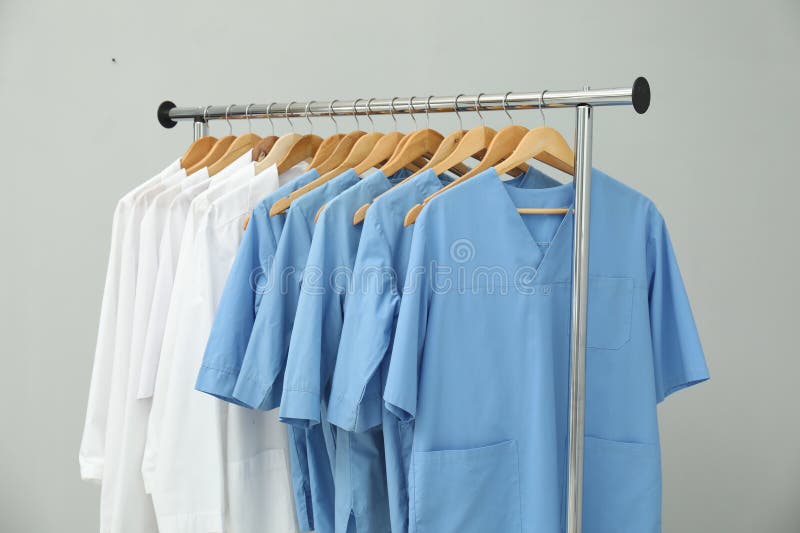 Different Medical Workers Uniforms Clothing Rack Against Grey ...