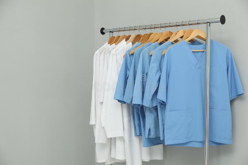 Different Medical Workers Uniforms Clothing Rack Against Grey ...