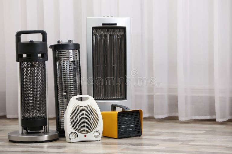Different Modern Electric Heaters on Floor in Room Stock Image - Image ...