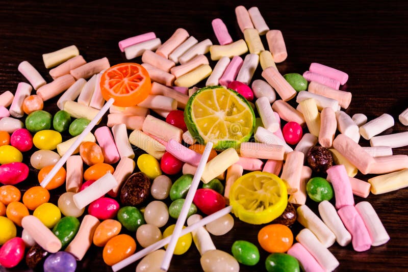 Different Multi Colored Candies on a Dark Wooden Table Stock Image ...
