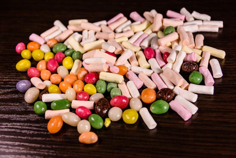 Different Multi Colored Candies on a Dark Wooden Table Stock Photo ...