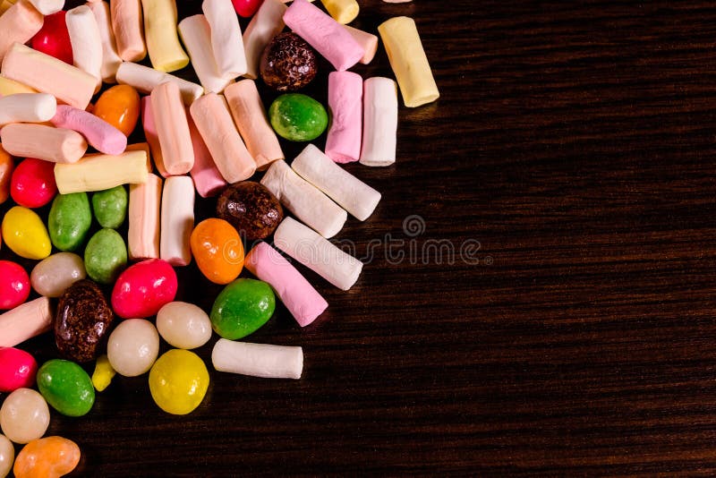 Different Multi Colored Candies on a Dark Wooden Table. Top View Stock ...