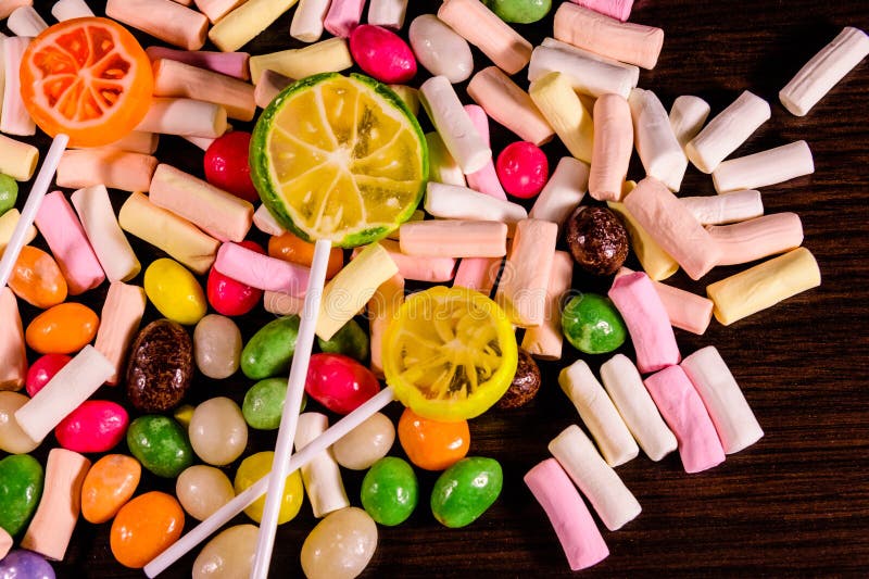 Different Multi Colored Candies on a Dark Wooden Table. Top View Stock ...