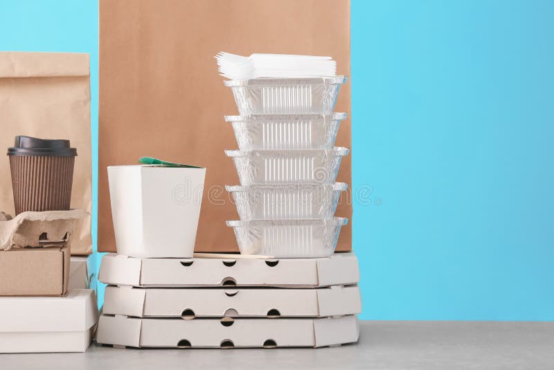 Different Packages and Carton Cups on Table Against Color Background ...