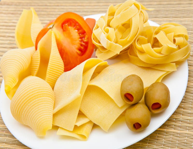 Different Pasta with Olives and Tomat on a Plate Stock Photo - Image of ...