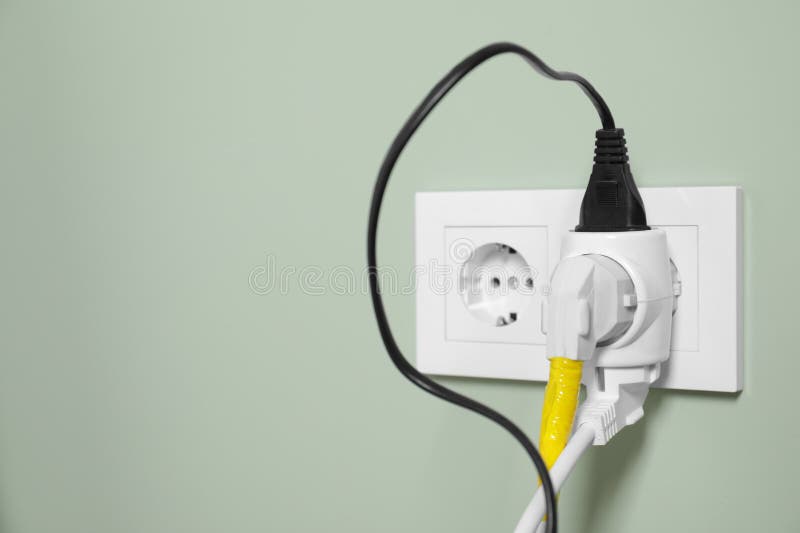 Different Power Plugs in Socket on Light Green Wall, Closeup. Space for ...