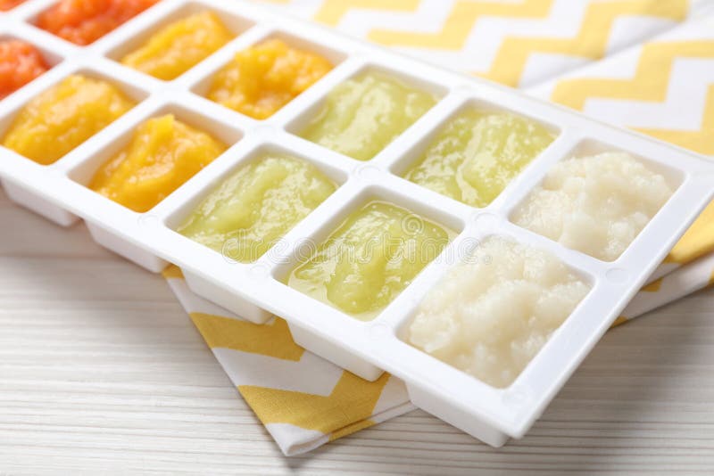 Different Purees in Ice Cube Tray on White Wooden Table, Closeup. Ready ...