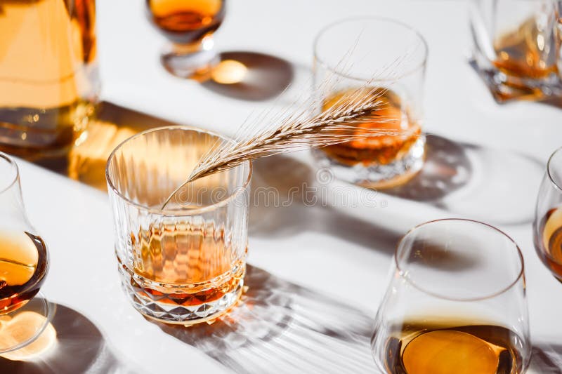 Different Shape Glasses with Whiskey on White Table Stock Photo - Image ...
