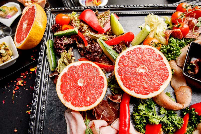 Different Snacks on the Table. Grapefruit in the Center. Also Sliced ...